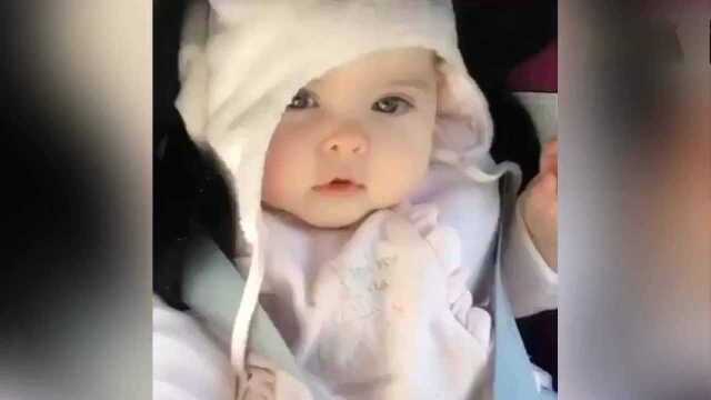 The little baby is sitting in the stroller and sings and sings, and the ...